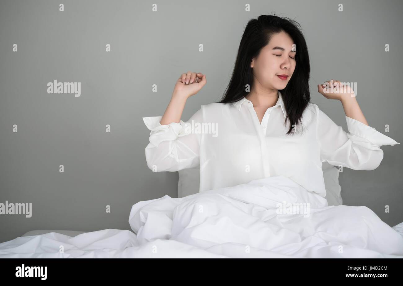Asian women wake up from sleep. are stretch herself in the morning on ...