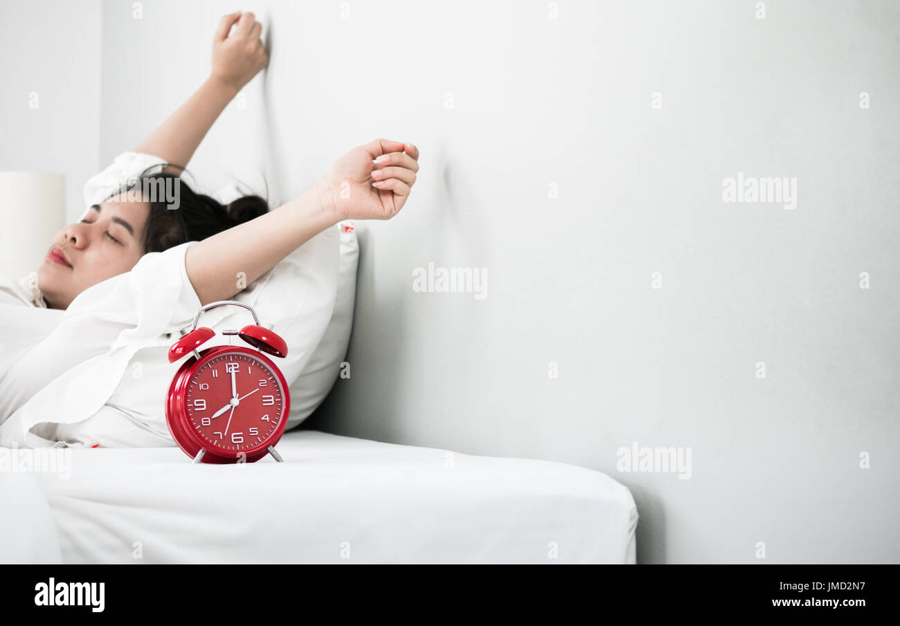 Asian women wake up from sleep. are stretch herself in the morning on ...