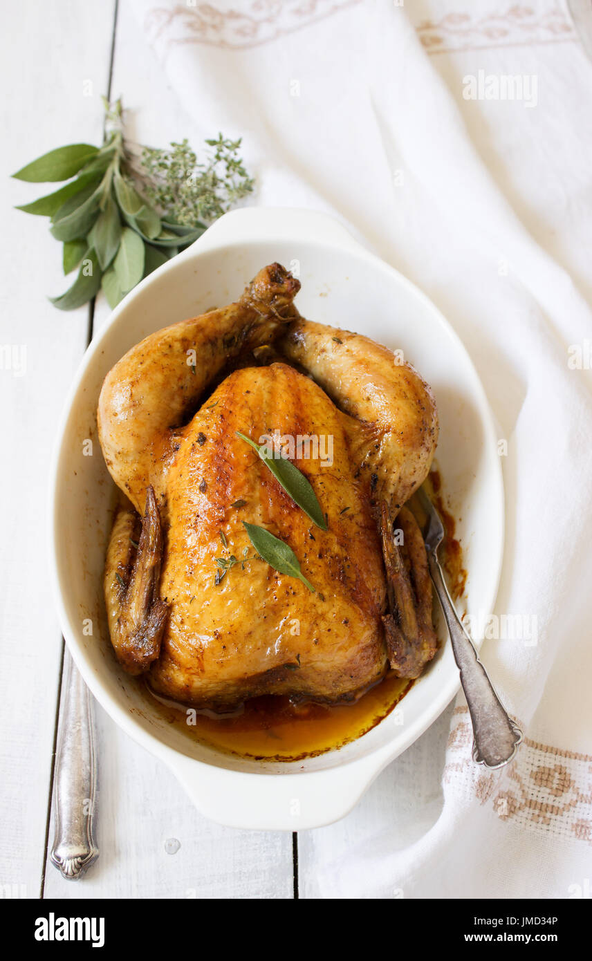 Baked chicken with herbs on a white background Stock Photo - Alamy