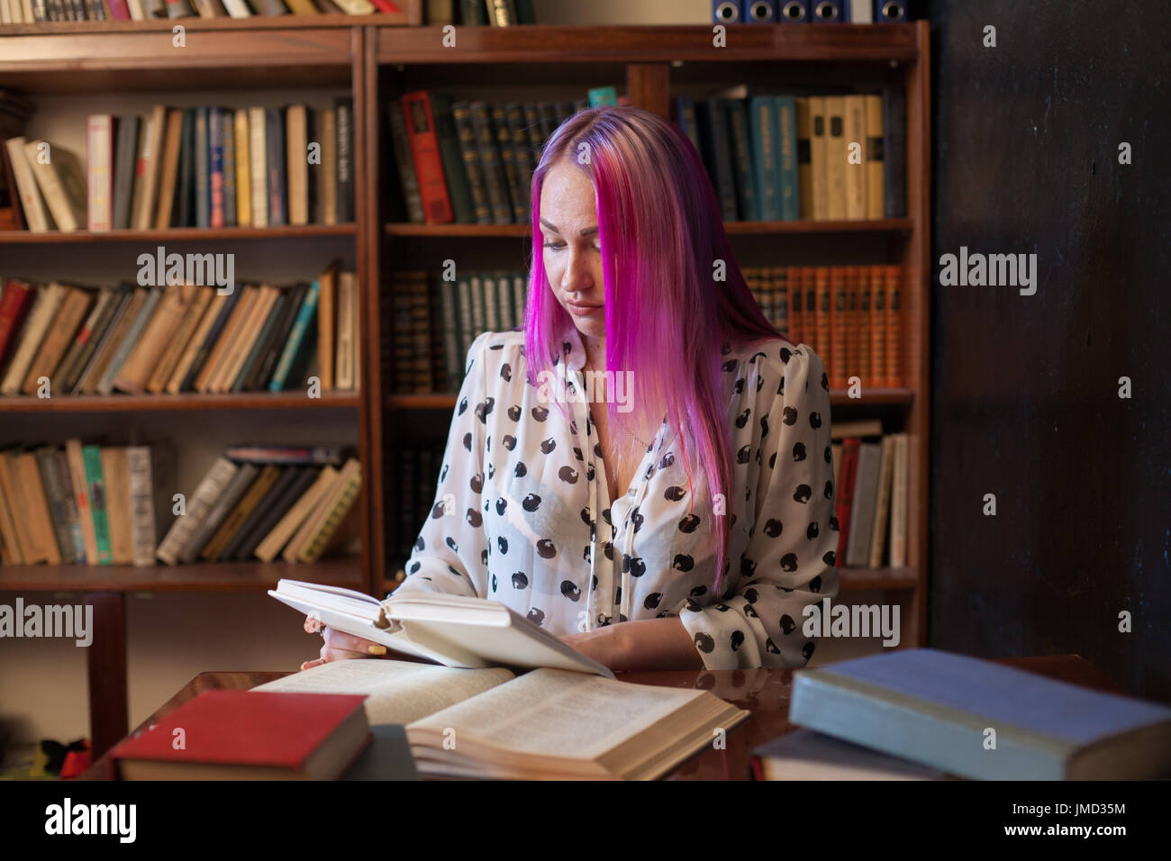 girl reading a book in the library is preparing for exams Stock Photo ...
