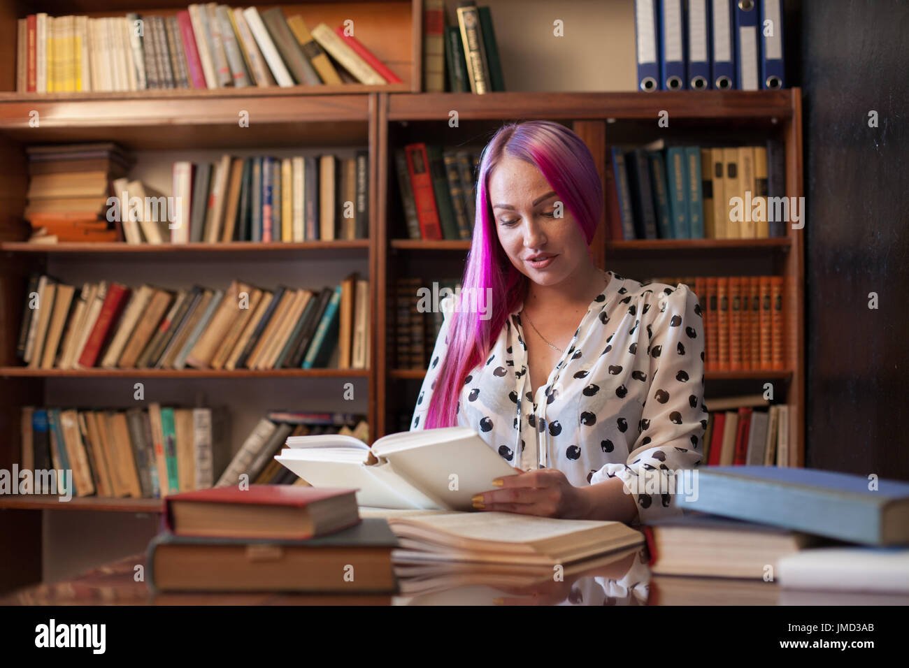 girl reading a book in the library is preparing for exams Stock Photo ...