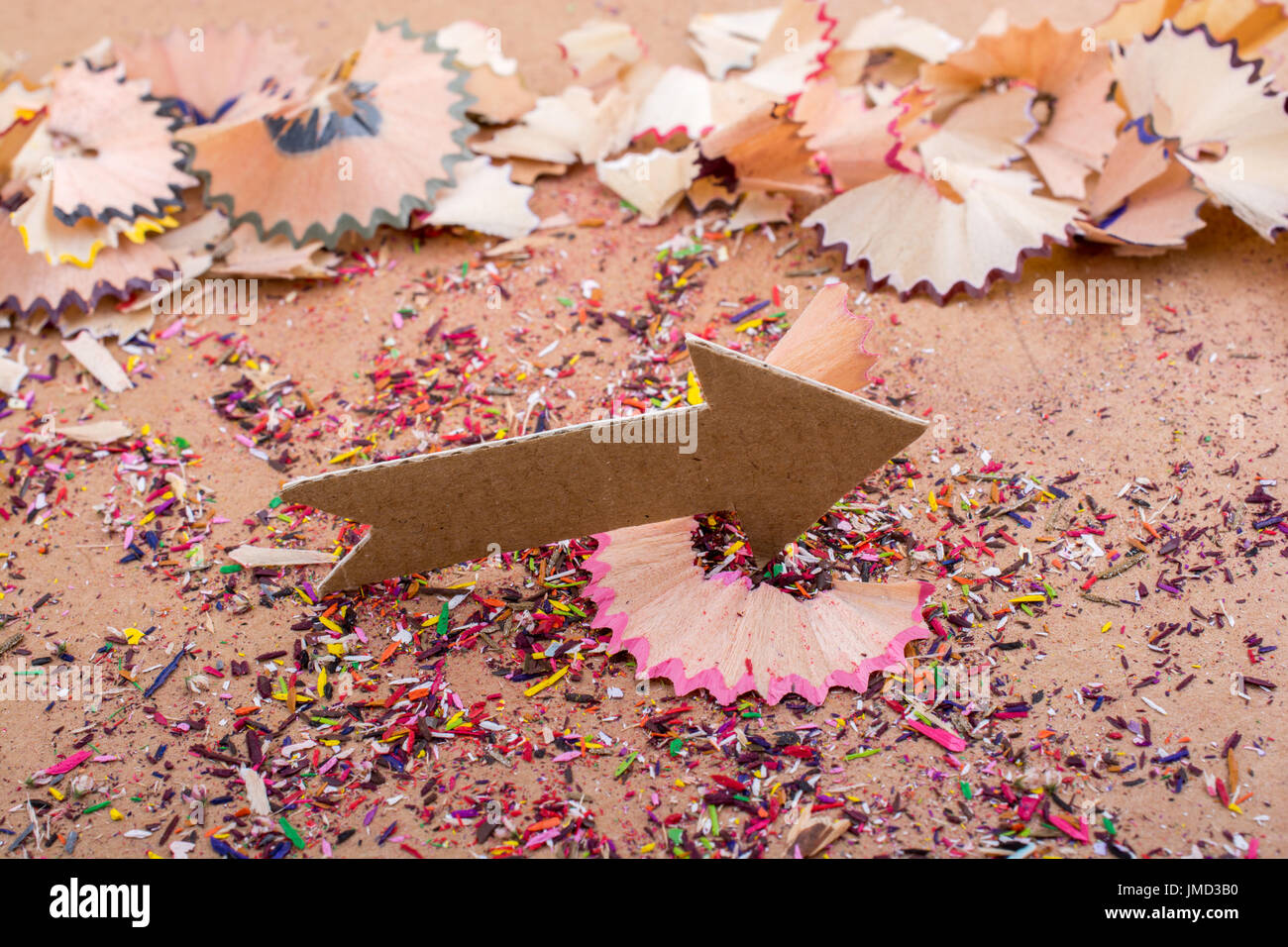 Arrow cut out of paper amid pencil shavings on canvas Stock Photo - Alamy