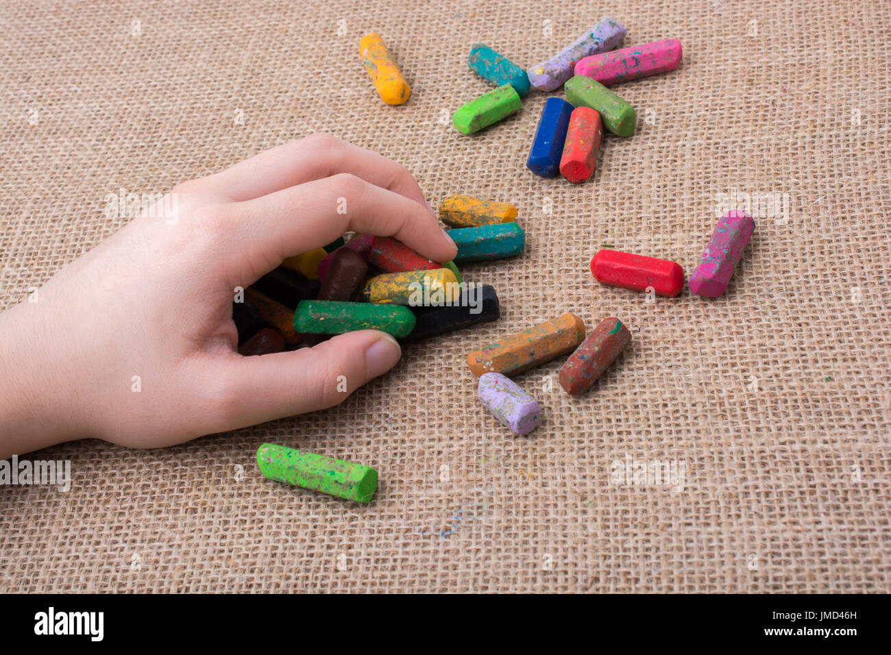 Used color crayons and a hand holding some Stock Photo - Alamy