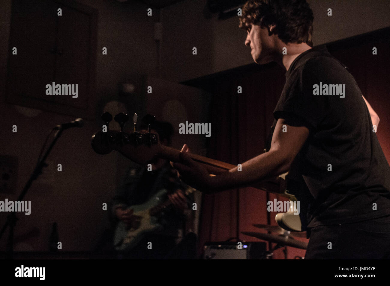 Bass guitar playing from behind Stock Photo - Alamy