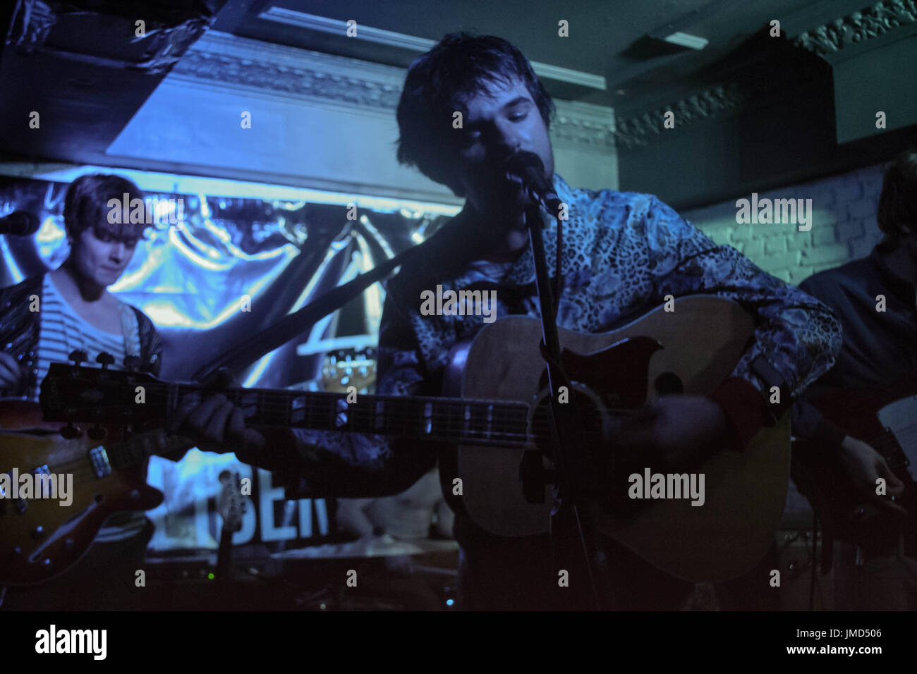 Man singing on stage with acoustic guitar Stock Photo - Alamy