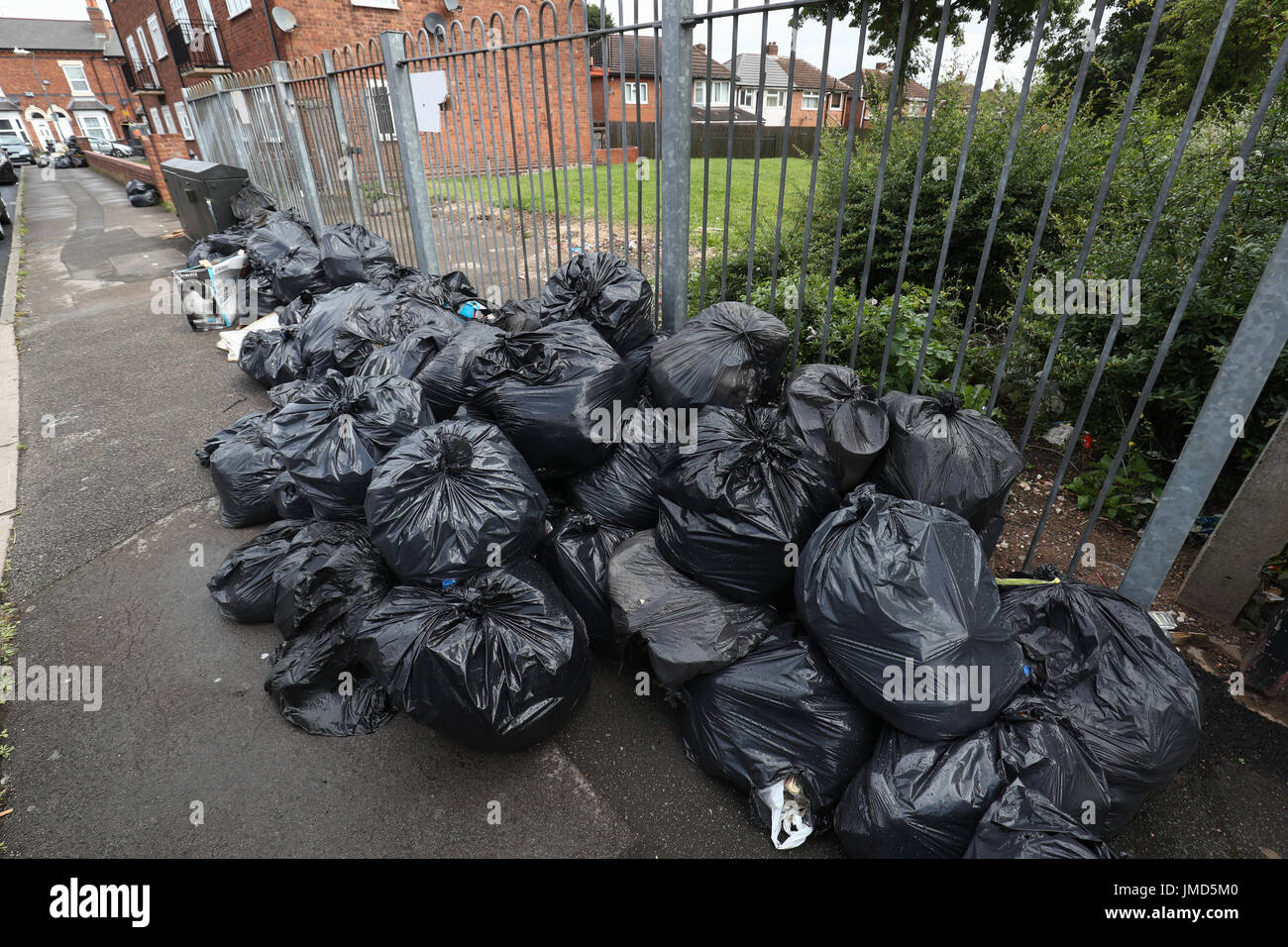 Rubbish bags piled high in tarry road hi-res stock photography and ...