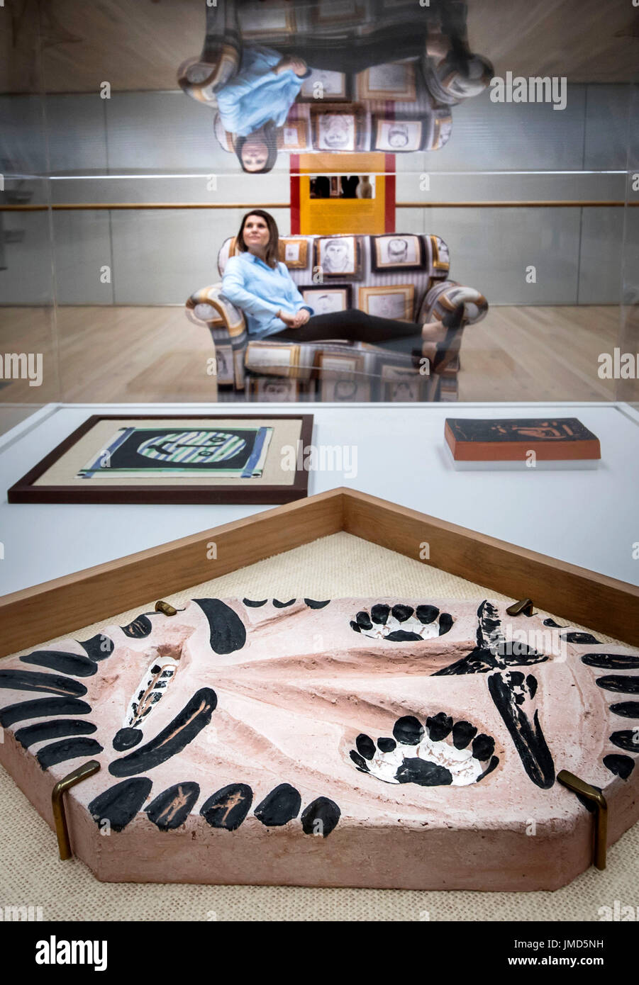 Gallery employee Lauren Masterman, is pictured reflected in a display ...
