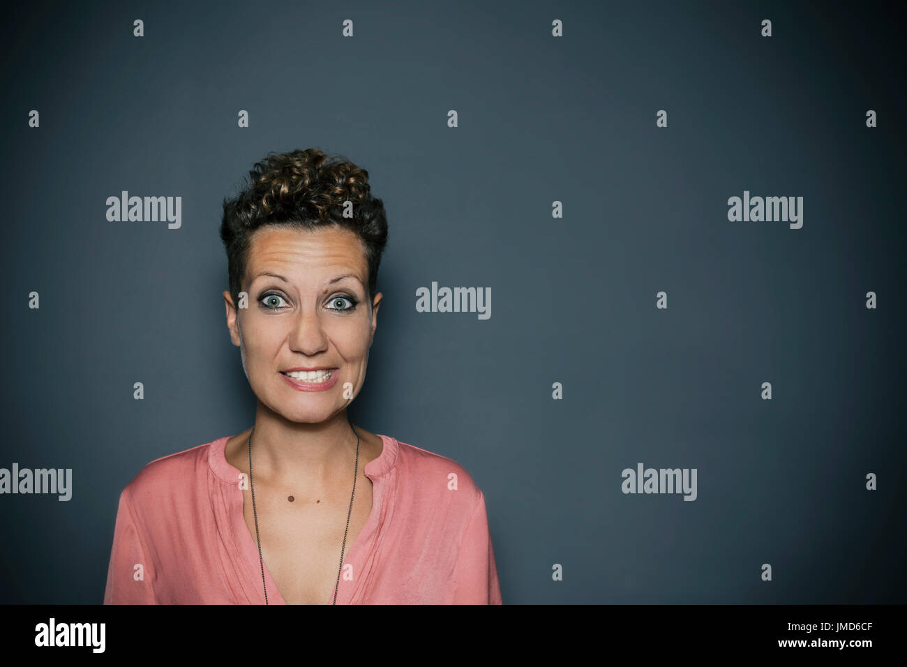Portrait of a young girl undecided, grey background Stock Photo - Alamy