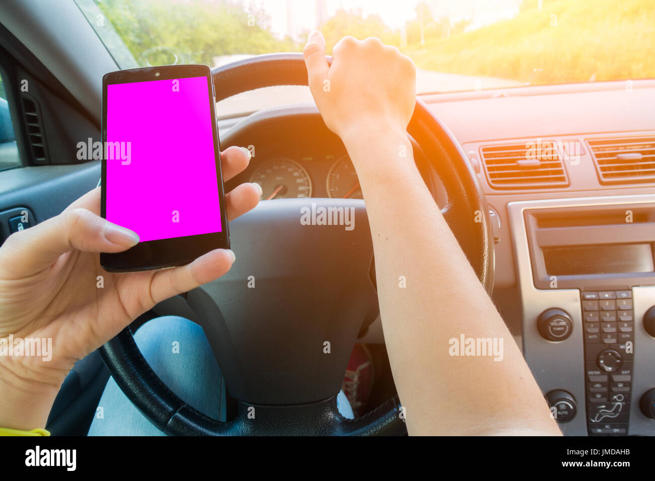 Girl holding smartphone with pink screen while driving in car Stock ...