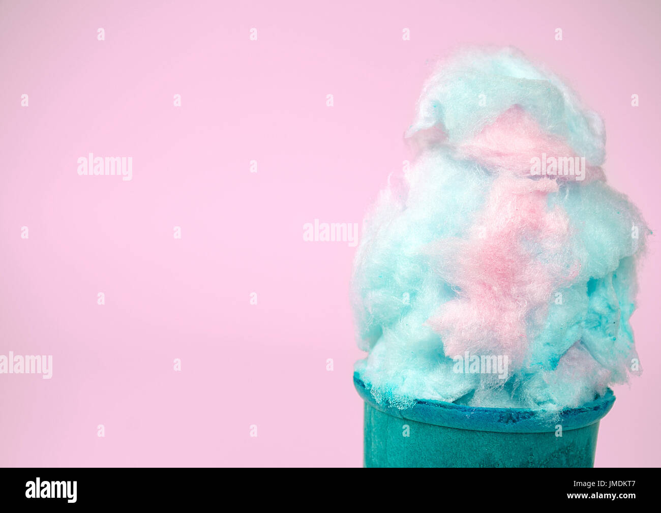 pink and aqua colored cotton candy in cone isolated on pastel pink ...