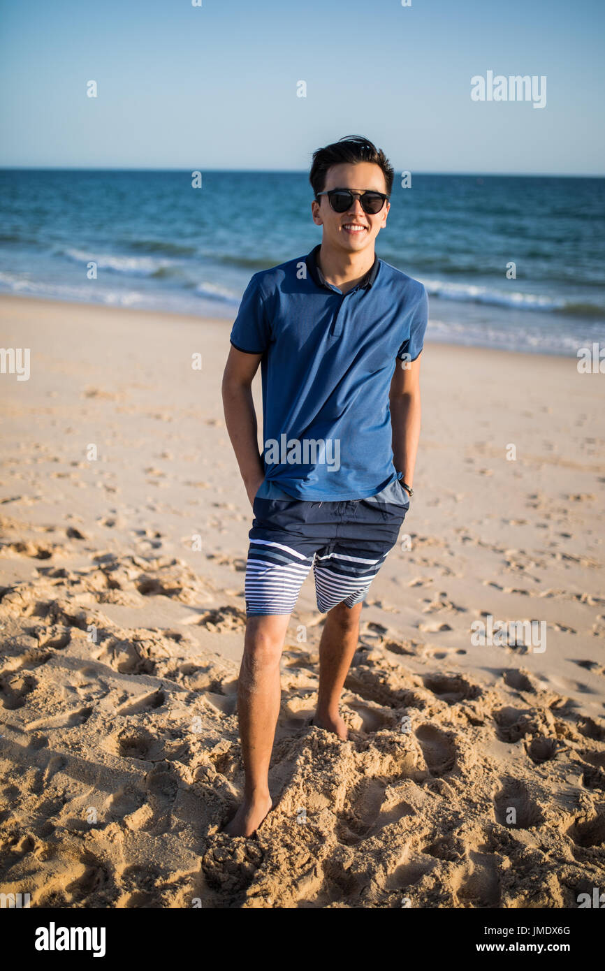 Relaxing and smiling young man on the beach Stock Photo - Alamy