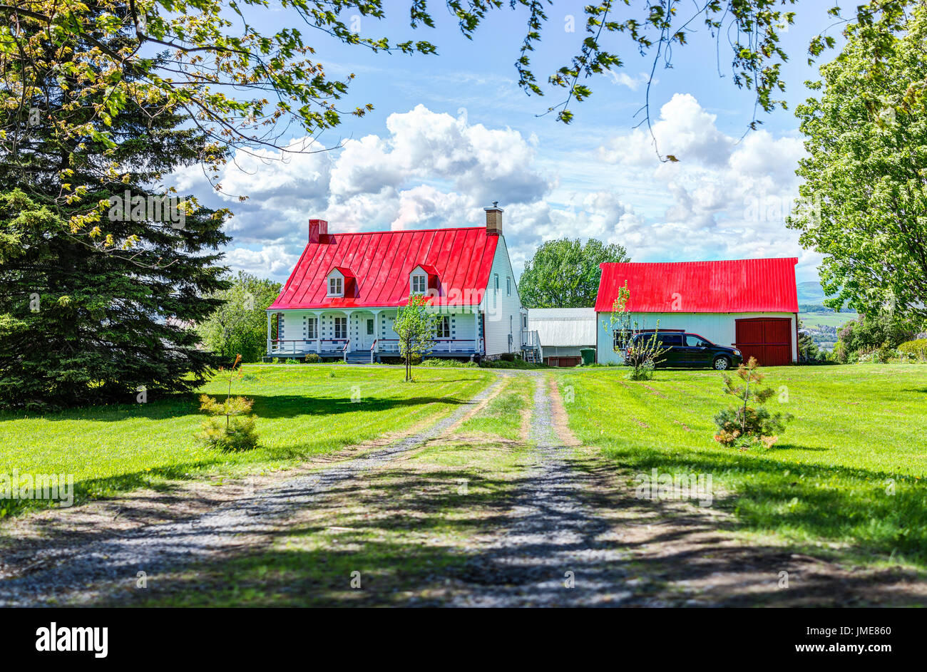 Ile D'Orleans, Canada - June 1, 2017: Red painted roof house with road ...