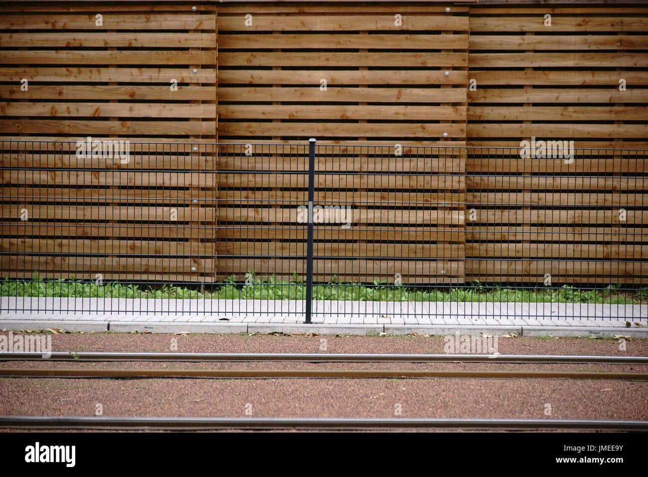 A newly built tram rail track with a fence and visual protection at the ...