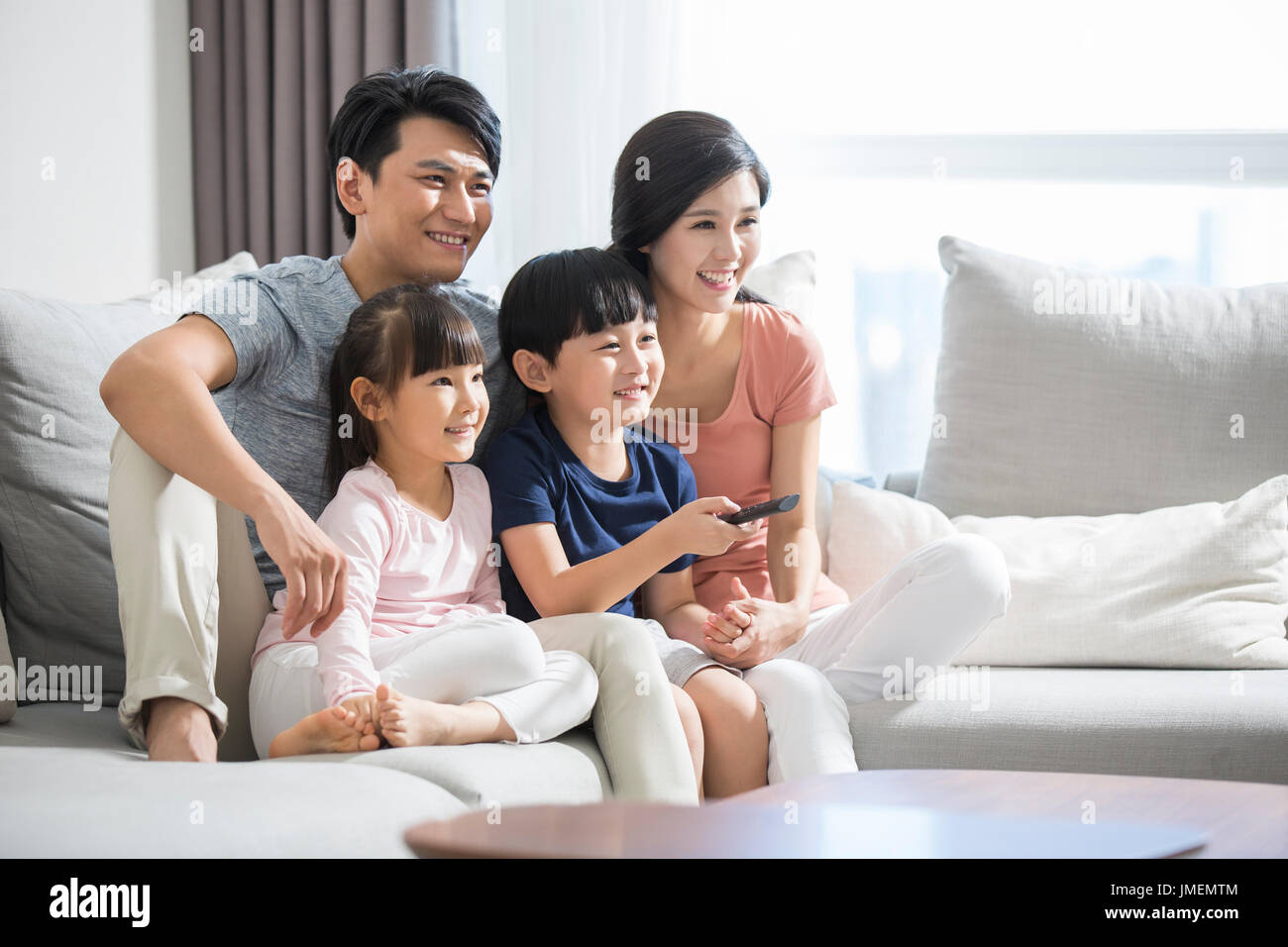 Happy young Chinese family watching TV Stock Photo - Alamy