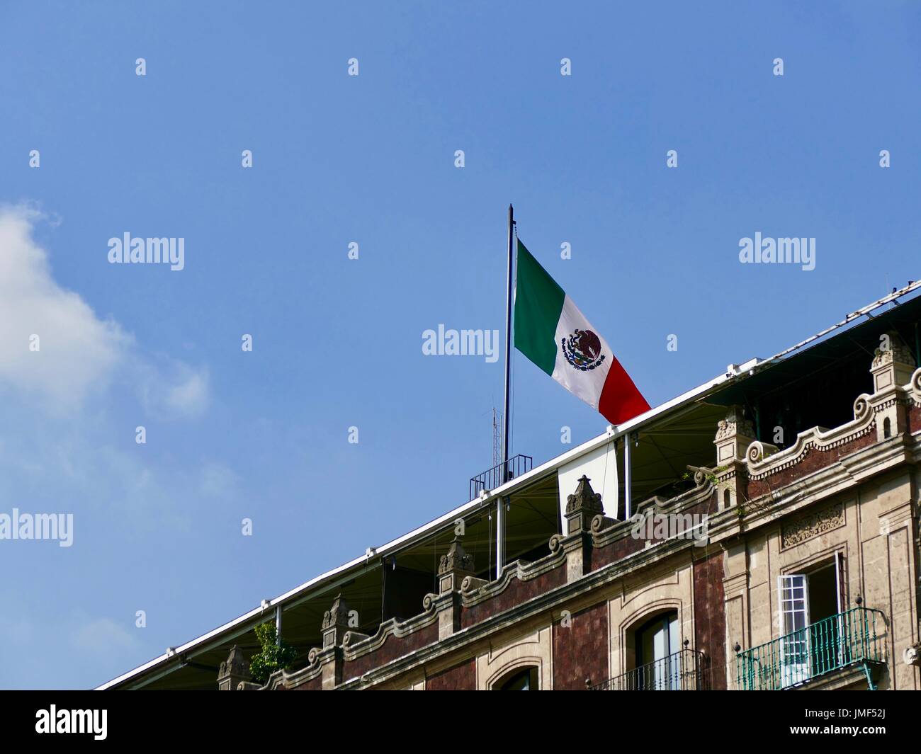 Mexican flag flying over the National Palace against blue sky, Mexico ...