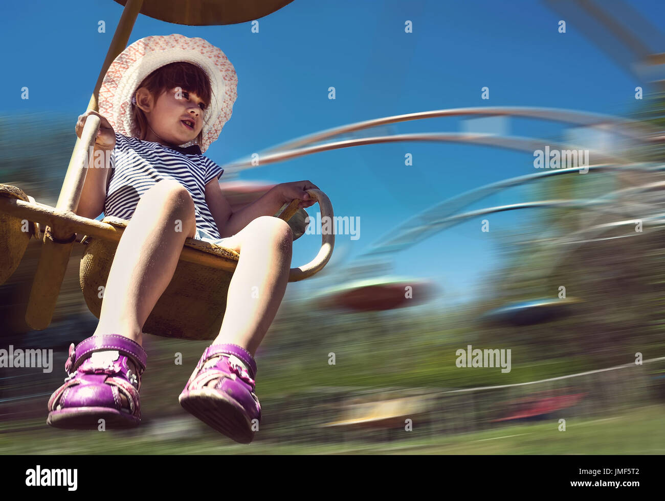 Happy girl having fun on the roundabout. a child is spinning on the ...