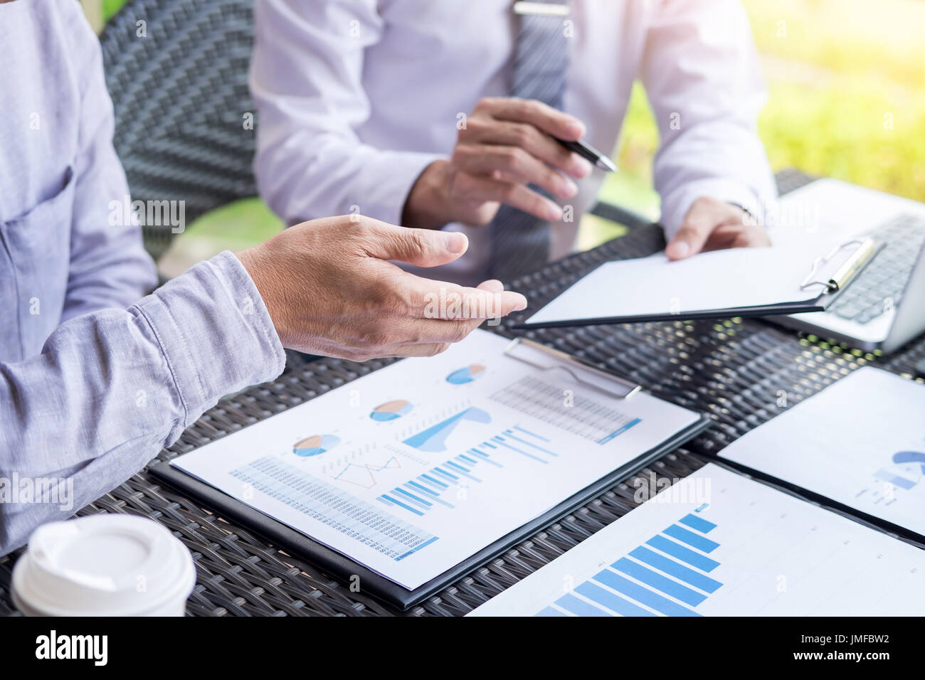 Business people discuss together about there work by graph document and ...