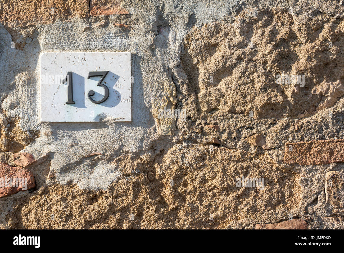 Road sign on a house reading the number thirteen made out of metalic ...