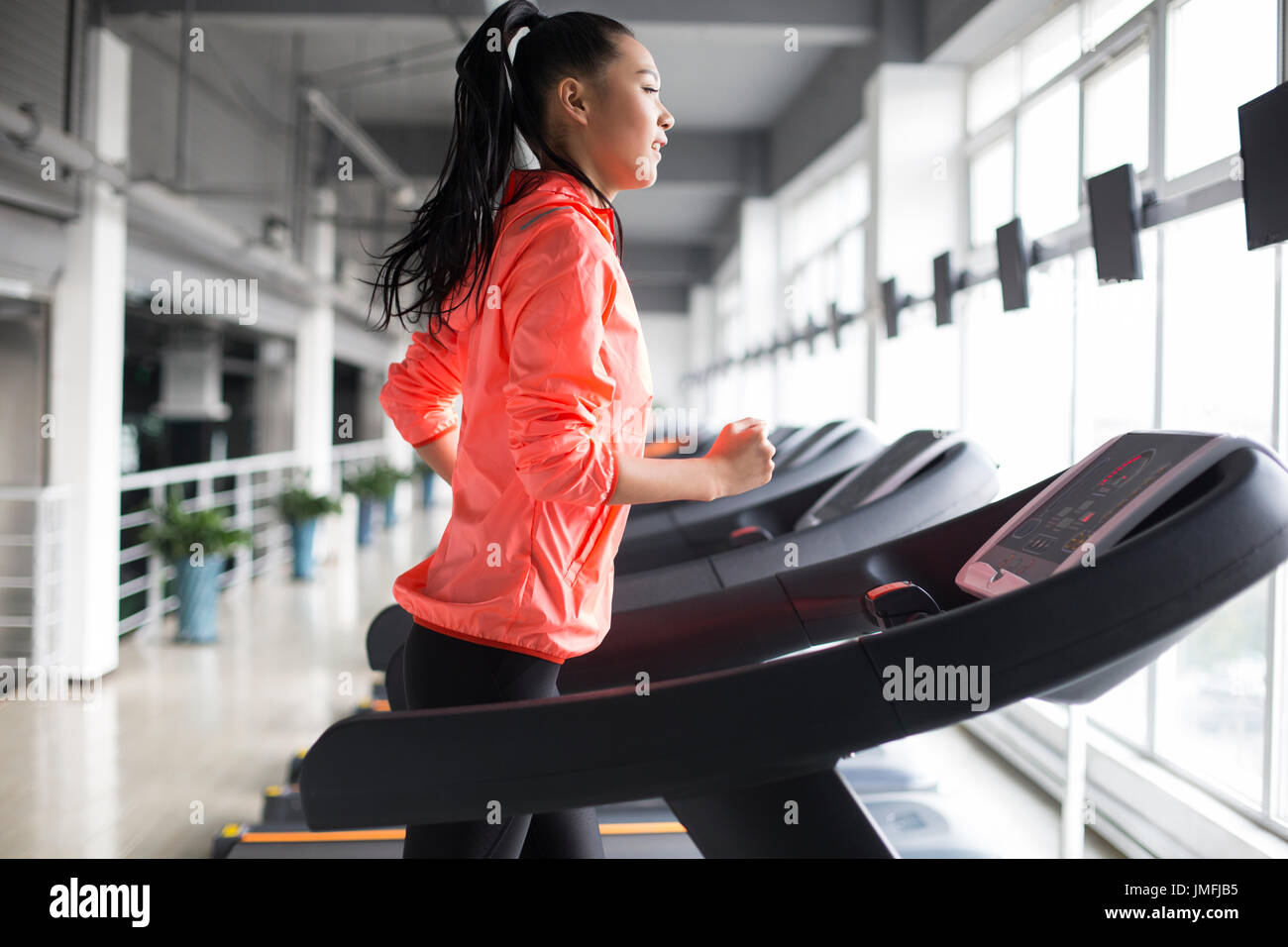 Young Chinese woman running on treadmill in gym Stock Photo - Alamy