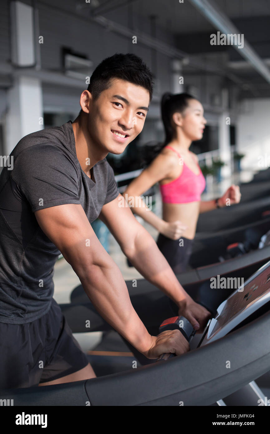 Young Chinese couple exercising on treadmills in gym Stock Photo - Alamy