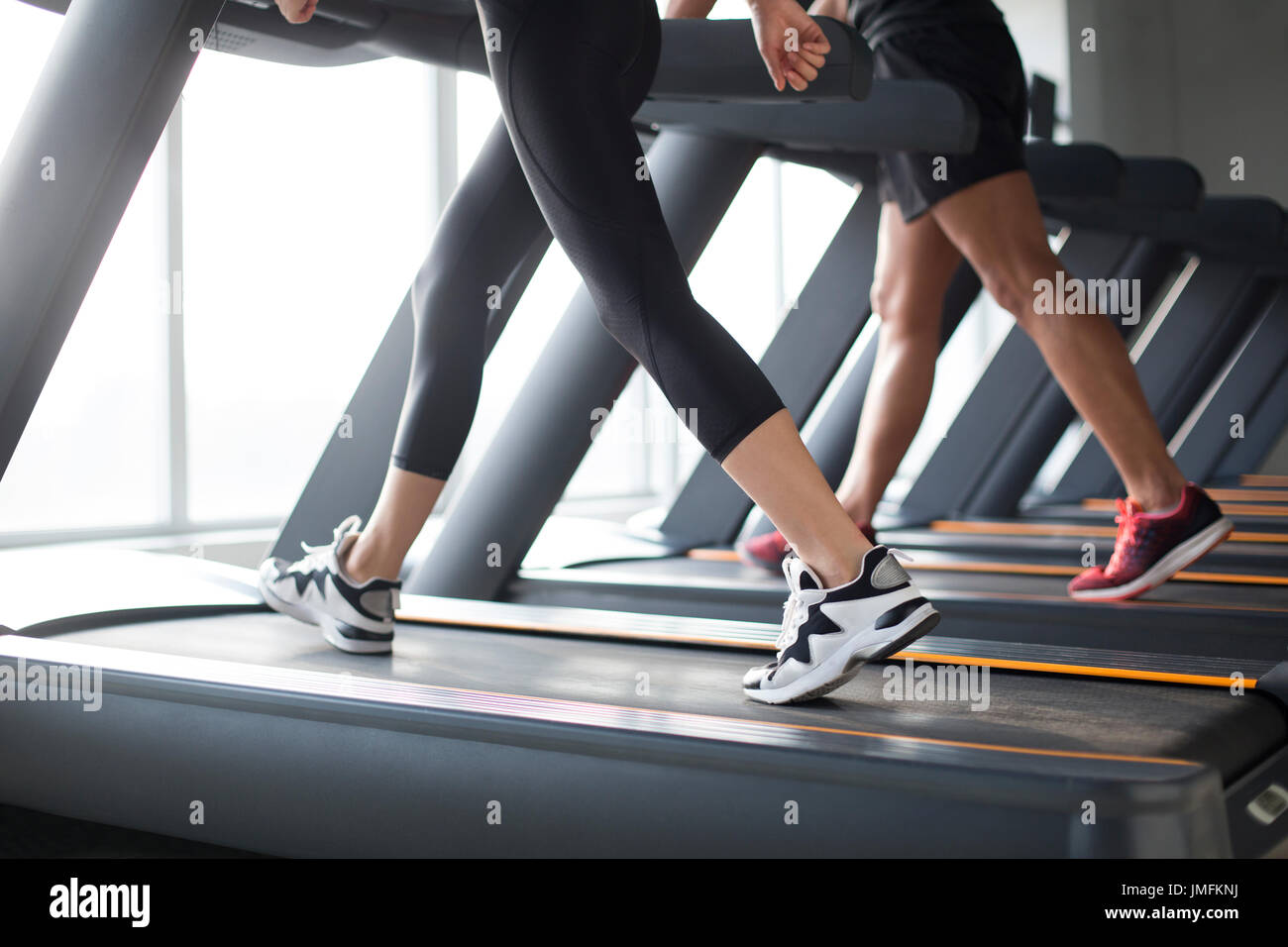 Young Chinese couple exercising on treadmills in gym Stock Photo - Alamy