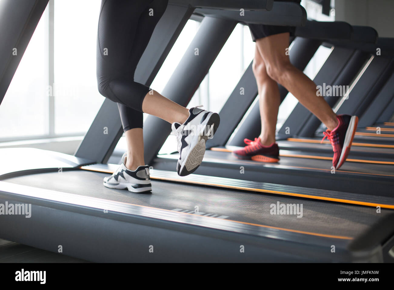 Young Chinese couple exercising on treadmills in gym Stock Photo - Alamy