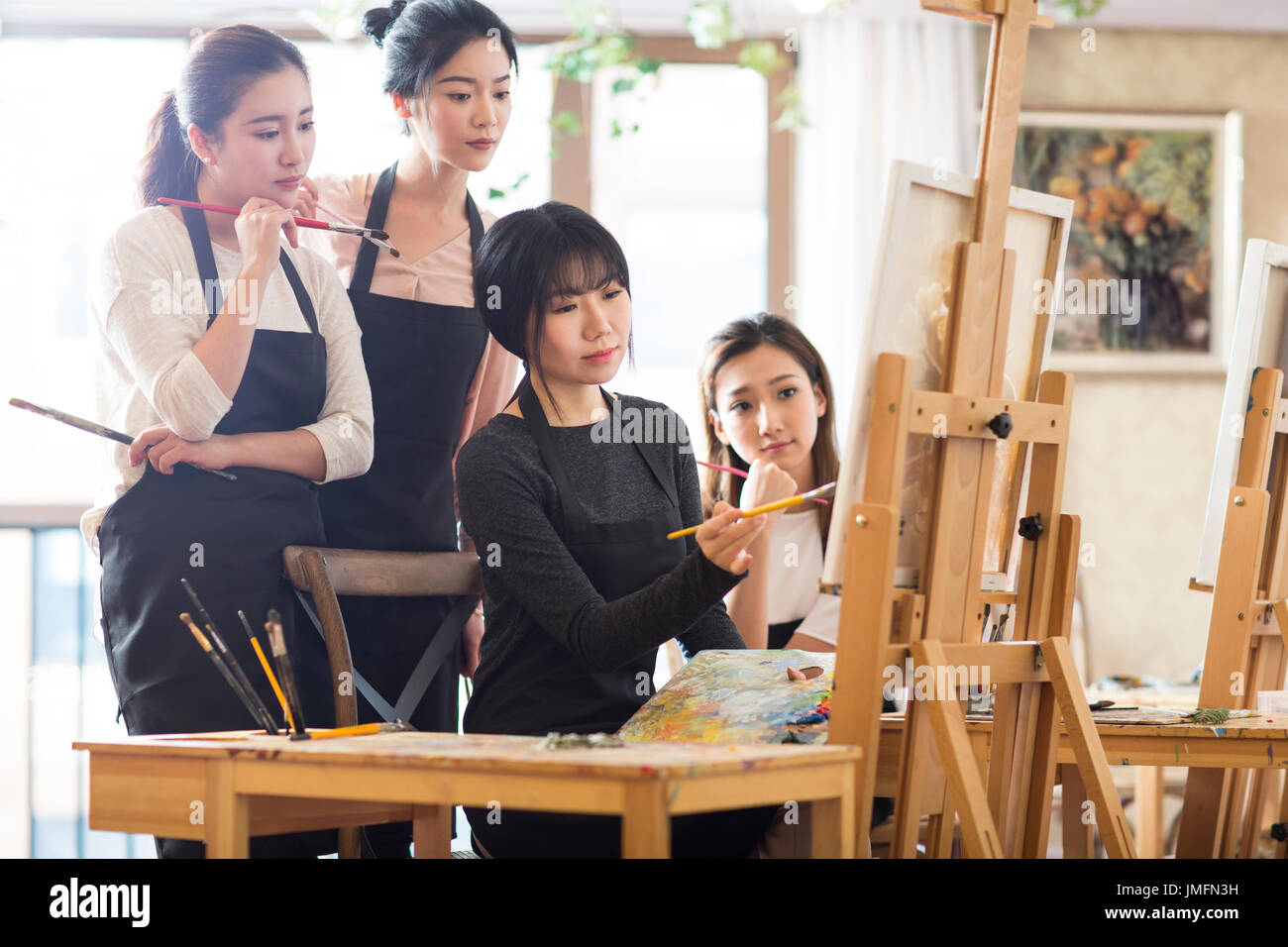 Art teacher with young women in studio Stock Photo - Alamy