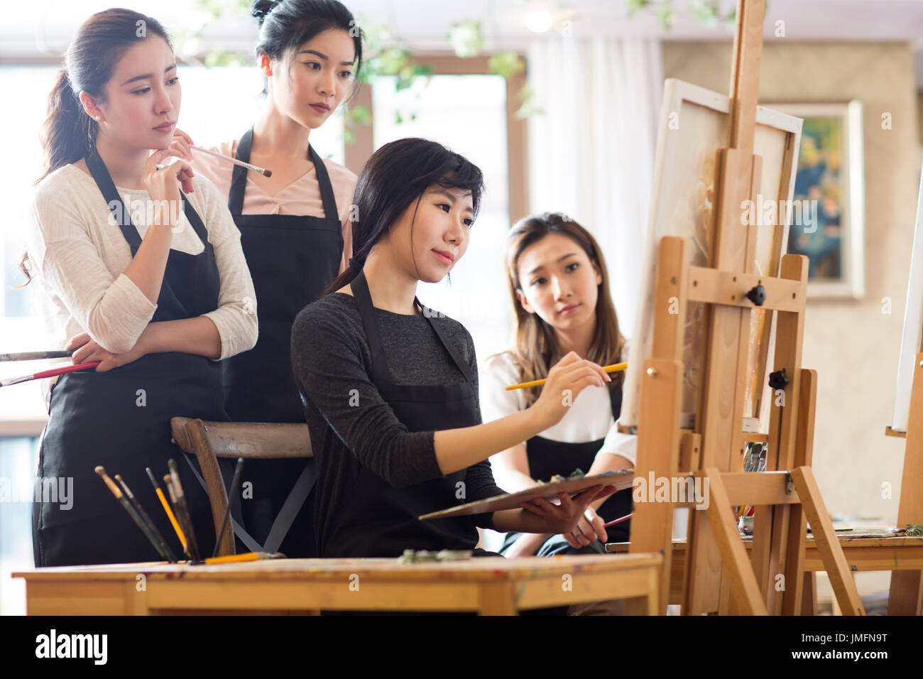 Art teacher with young women in studio Stock Photo - Alamy