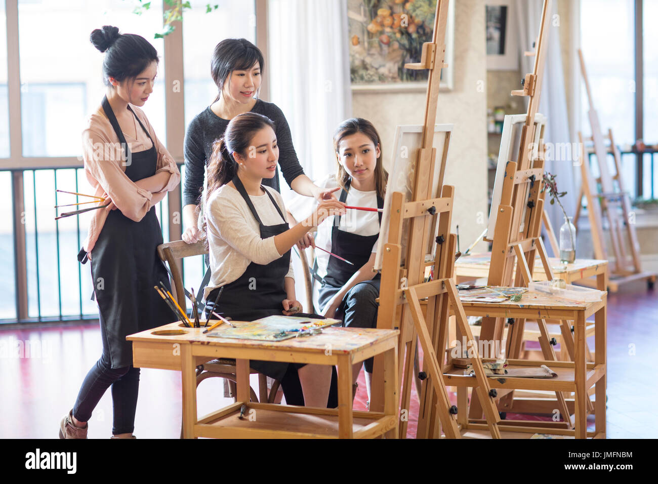 Art teacher with young women in studio Stock Photo - Alamy