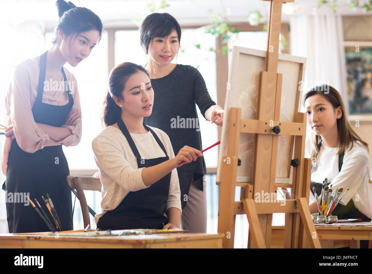 Art teacher with young women in studio Stock Photo - Alamy