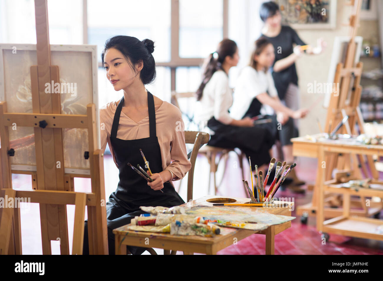 Young woman painting in art class Stock Photo - Alamy