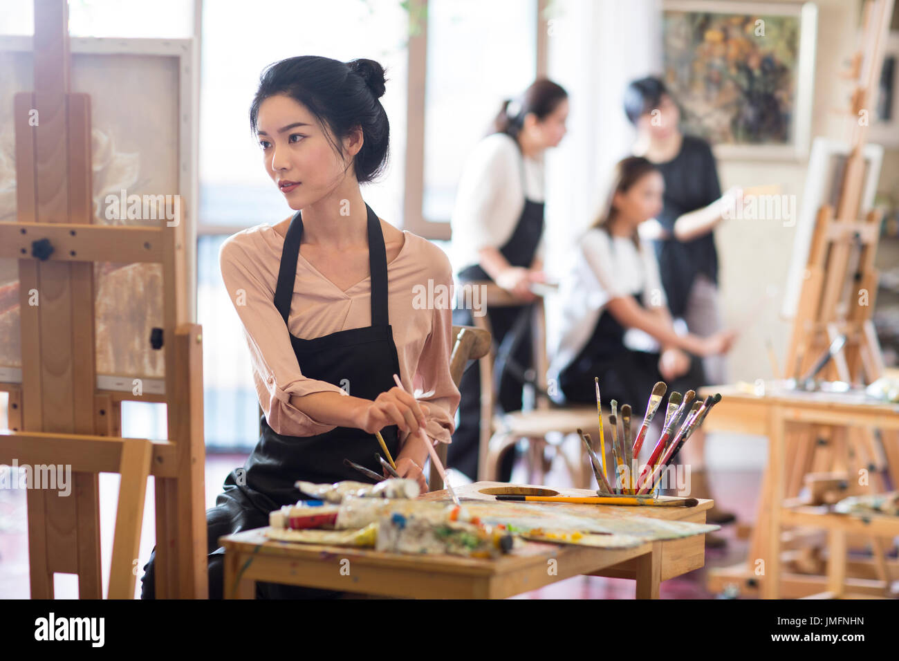 Young woman painting in art class Stock Photo - Alamy