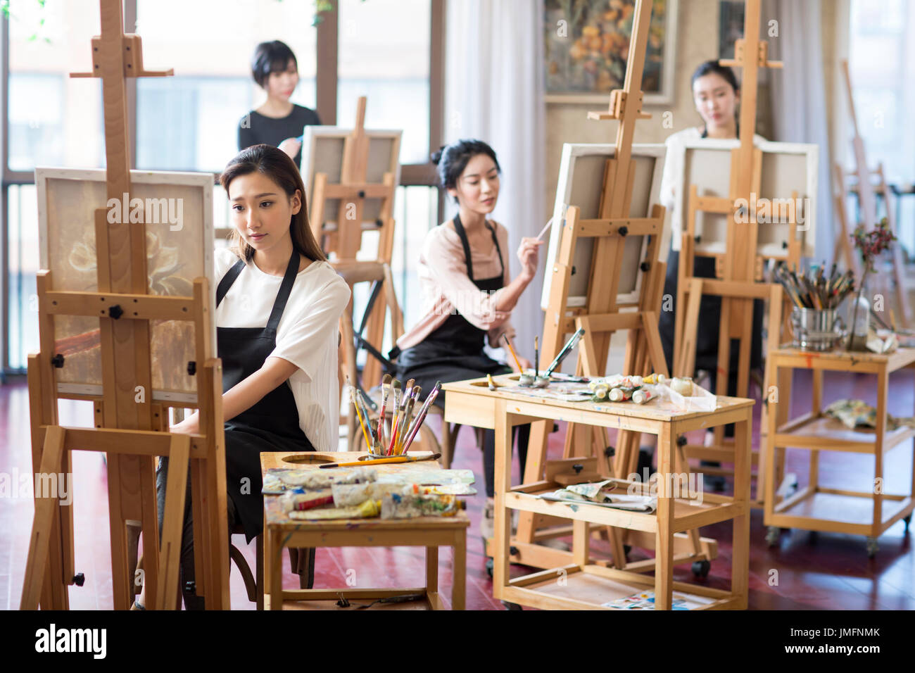 Young women painting in art class Stock Photo - Alamy