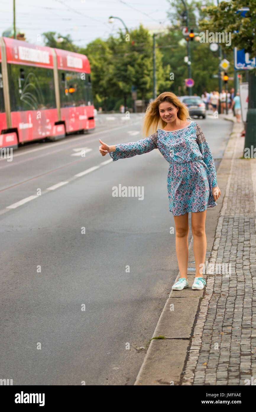 Young woman doing the hitch-hiking in a street of a city Stock Photo ...