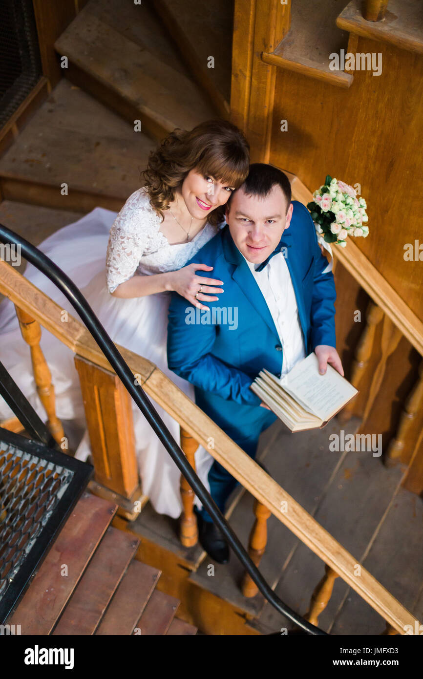 Down view of the smiling newlywed couple hugging while standing on the ...