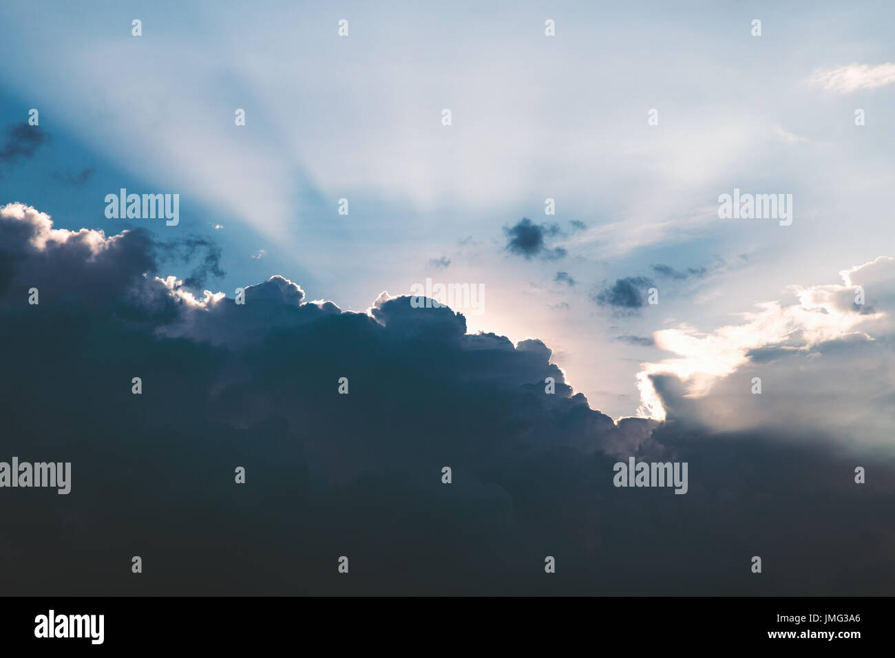 Dark cloud cover shining sun ray on cold winter blue sky Stock Photo ...
