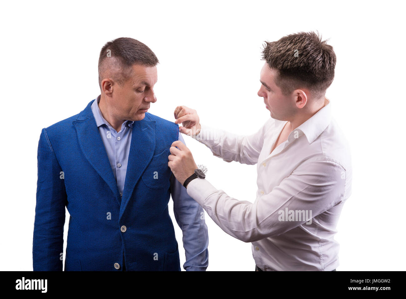 male tailor designer make marks on a jacket during bespoke suit fitting ...