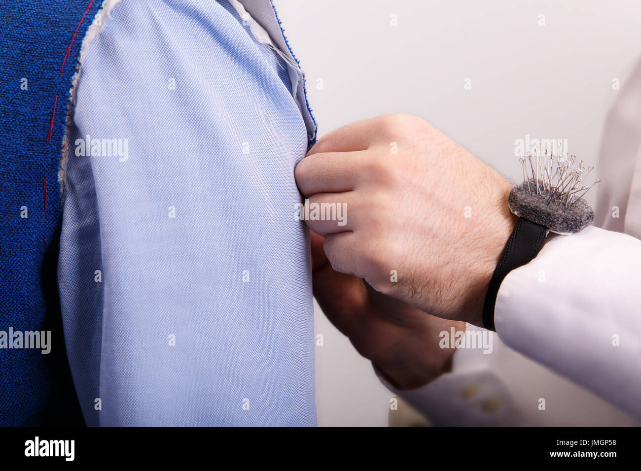 tailor designer make marks on a jacket during bespoke suit fitting ...