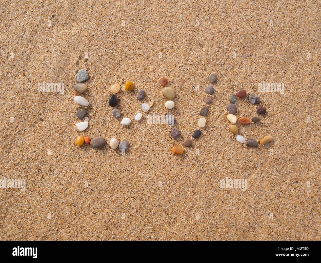 word love written with stones and shells on the beach by the ocean ...