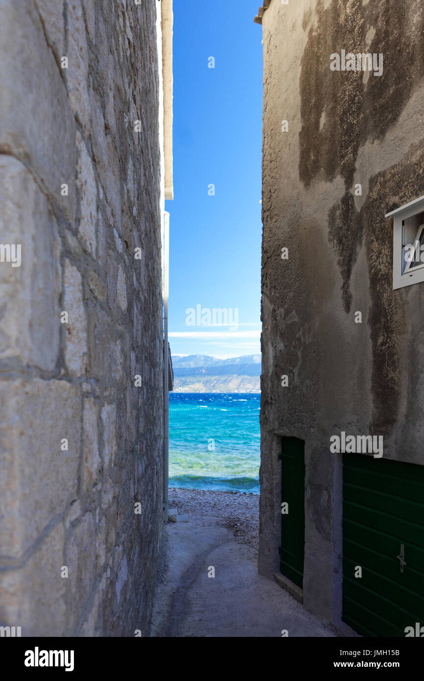 Narrow path between buildings to a beach - Croatia, Brac Stock Photo ...