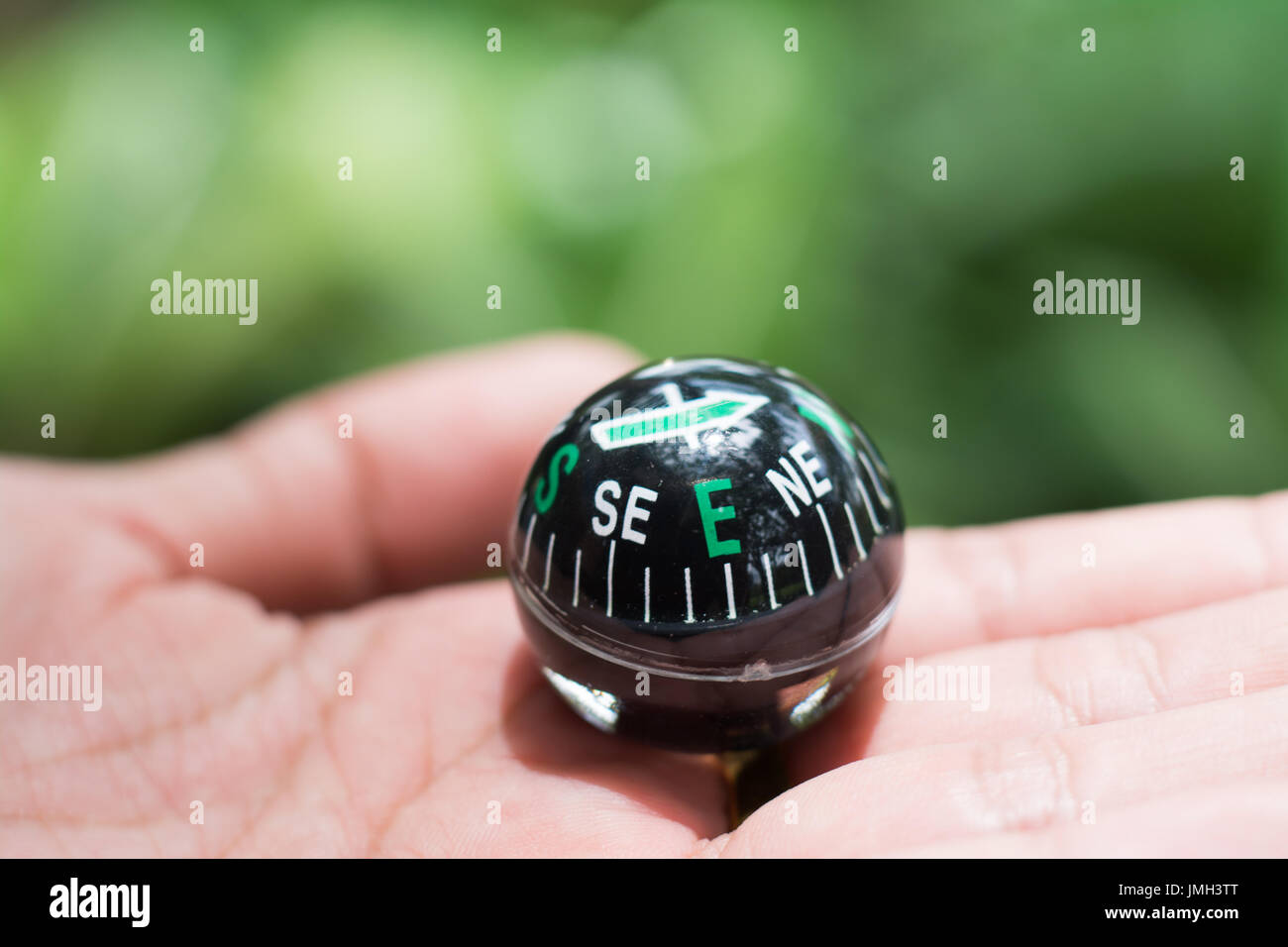 Hand holding a black compass using as an exploration, adventure ...