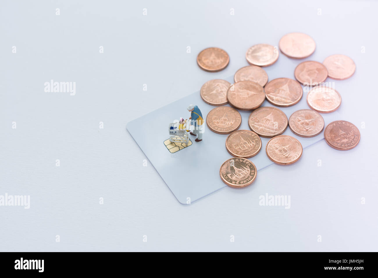 Miniature shoppers with shopping cart figure on a credit card or debit ...