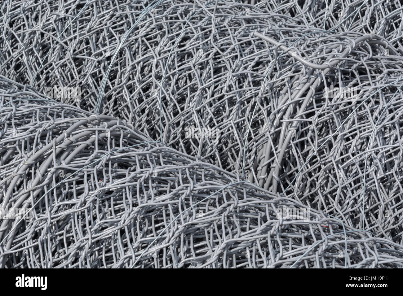 Toughened wire mesh used for retaining cliff face rockfalls and in the ...