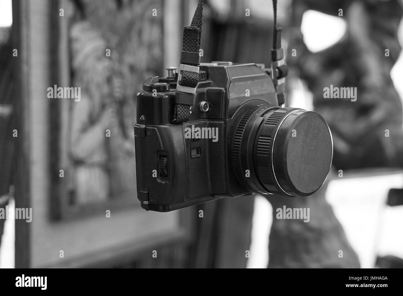 old retro vintage black film camera with lens attached hanging on a ...