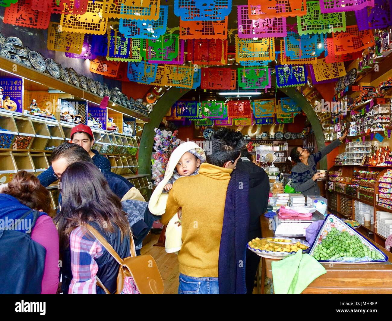 Family, shoppers, and interior of colourful Mexican tourist shop with ...