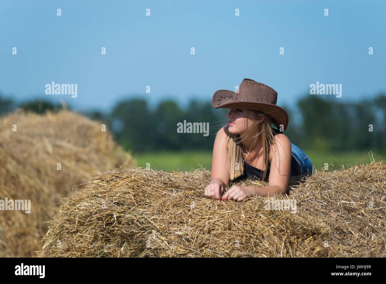 Pretty young girl on a haystack Stock Photo - Alamy