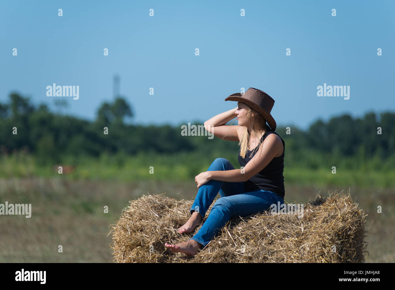 Pretty young girl on a haystack Stock Photo - Alamy