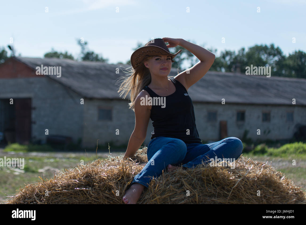 Pretty young girl on a haystack Stock Photo - Alamy