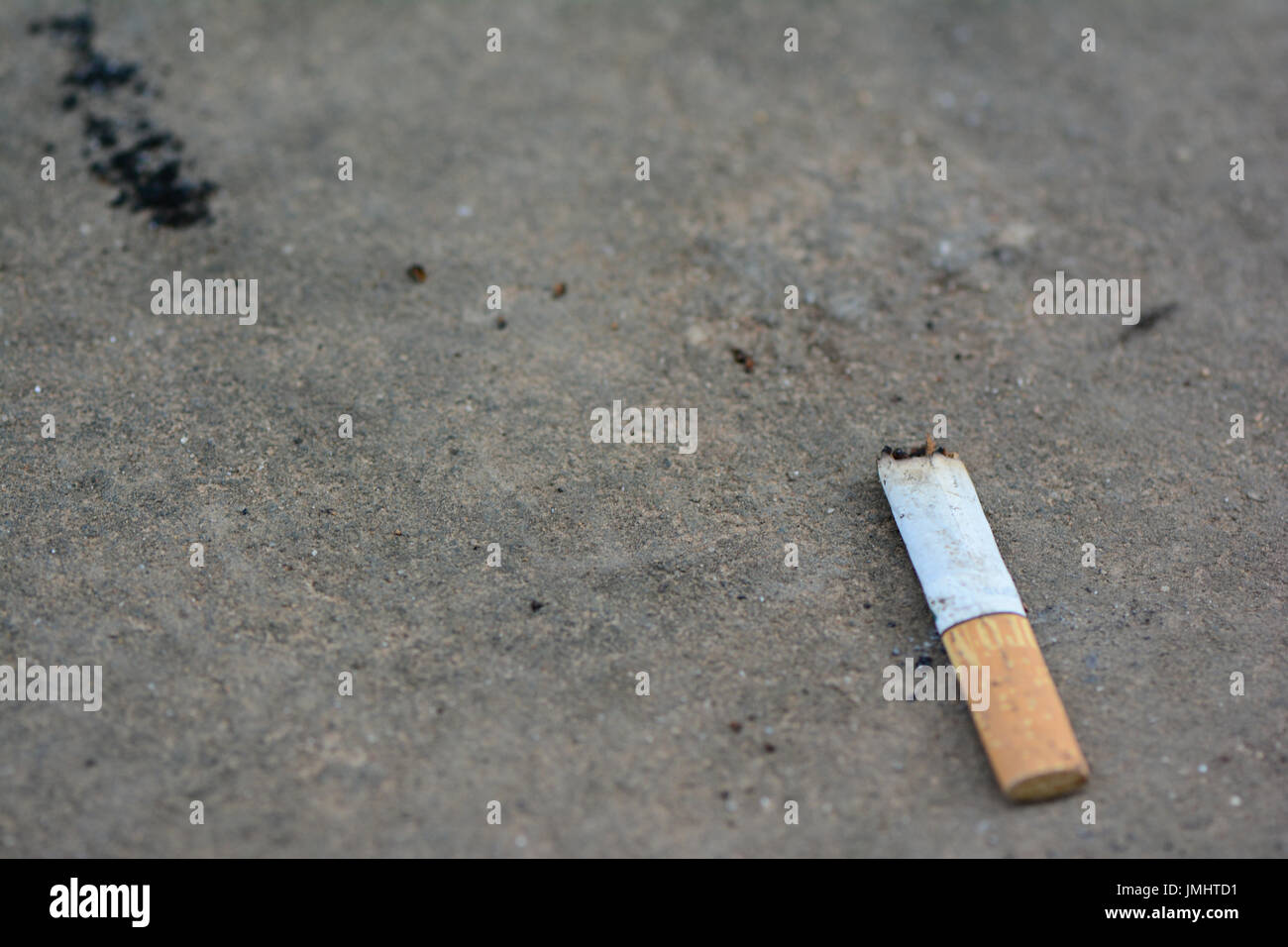 Used cigarette on the cemen floor Stock Photo - Alamy