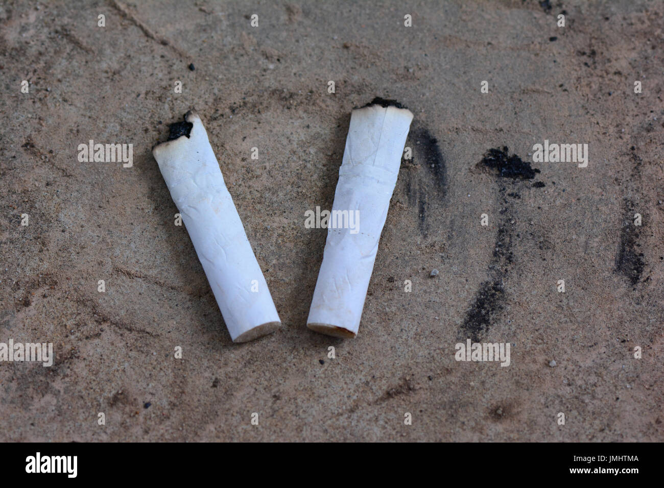 Couple of used cigarette on the floor Stock Photo - Alamy